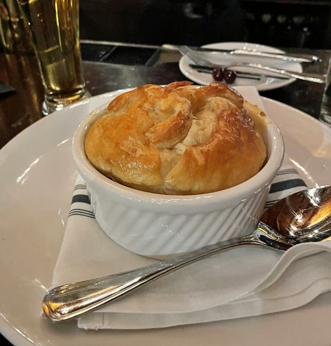 The pot pie arrives puffed and golden, like a pastry hot air balloon that's landed on your table.