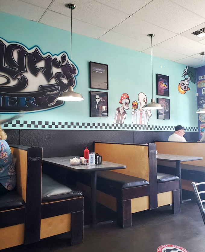 Turquoise walls and checkered trim create that perfect diner aesthetic. Even the cartoon characters on the wall look hungry for what's coming out of the kitchen.