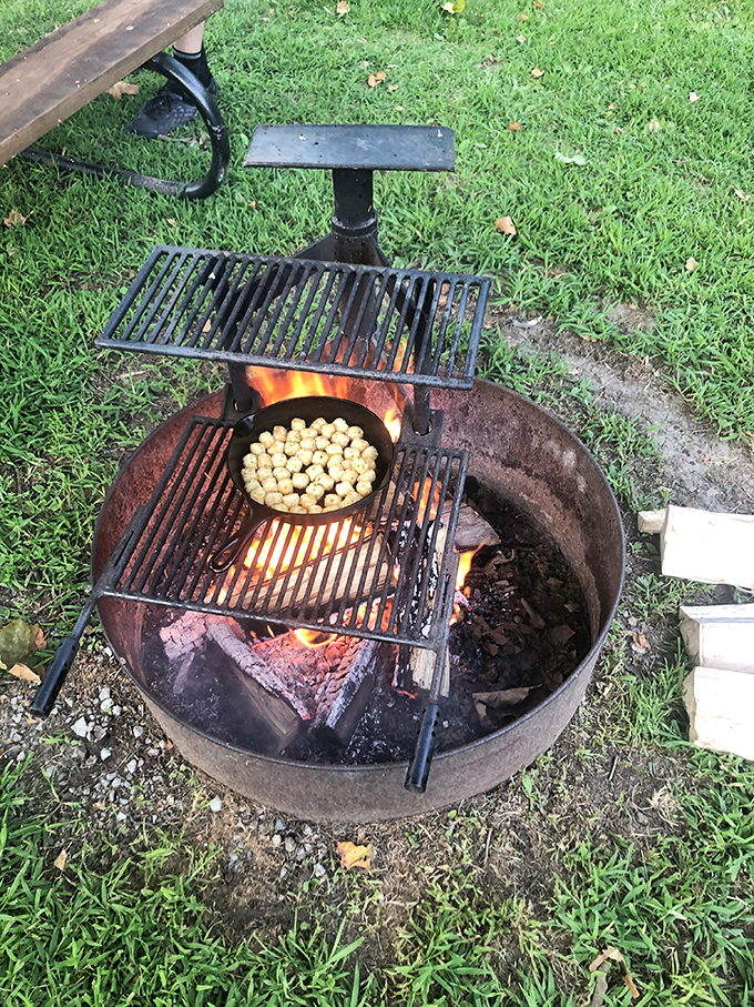 Nothing says "camping done right" like a crackling fire with dinner in progress. Those tater tots are about to experience a smoky transformation.