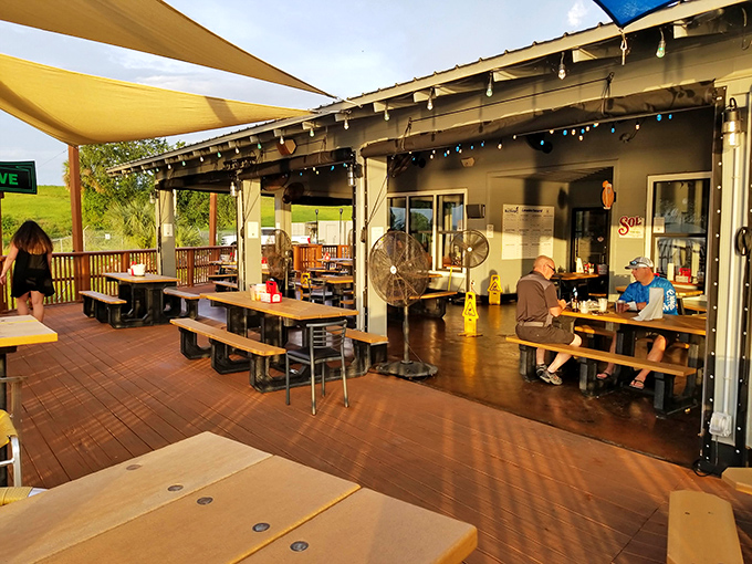 Sun-dappled outdoor seating where ceiling fans stir the salt air &ndash; the kind of porch that makes you want to cancel all afternoon appointments.