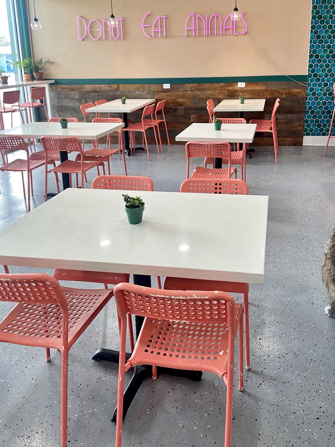 "DON'T EAT ANIMALS" glows in neon as a cheeky reminder. The minimalist space with pops of coral creates the perfect backdrop for pastry appreciation.