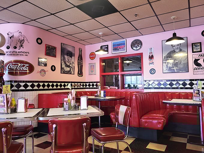 Red booths cradle conversations while vintage Coca-Cola signs and classic movie stars watch over diners from their place on pink walls.
