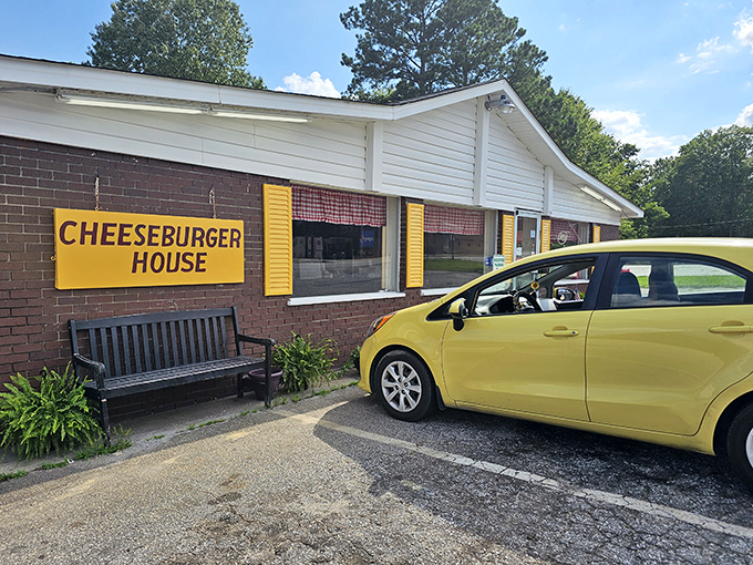 The cheerful yellow sign and welcoming bench say "come on in" – while the potted plants add a touch of homey charm.