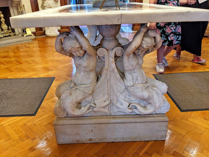 These marble cherubs have been holding up that table longer than most of us have held our gym memberships.