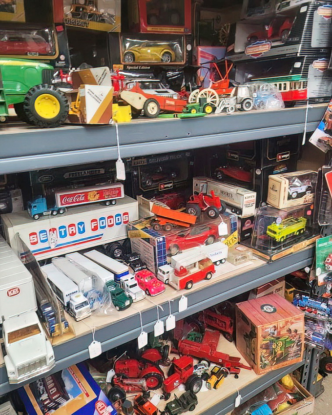Toy trucks and tractors park neatly on shelves, ready to spark imagination or rekindle memories of childhood adventures in miniature worlds.