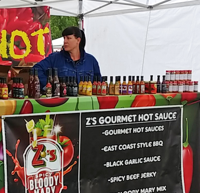 Z's Gourmet Hot Sauce vendor stands ready to transform your bland existence into a five-alarm flavor emergency. Your taste buds have been warned.