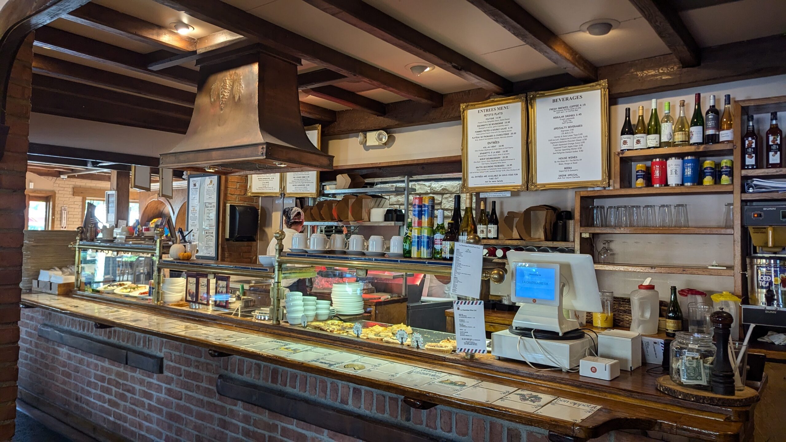 Behind the counter, where French culinary magic happens daily&mdash;menus in gold frames because when food is this good, it deserves proper introduction.