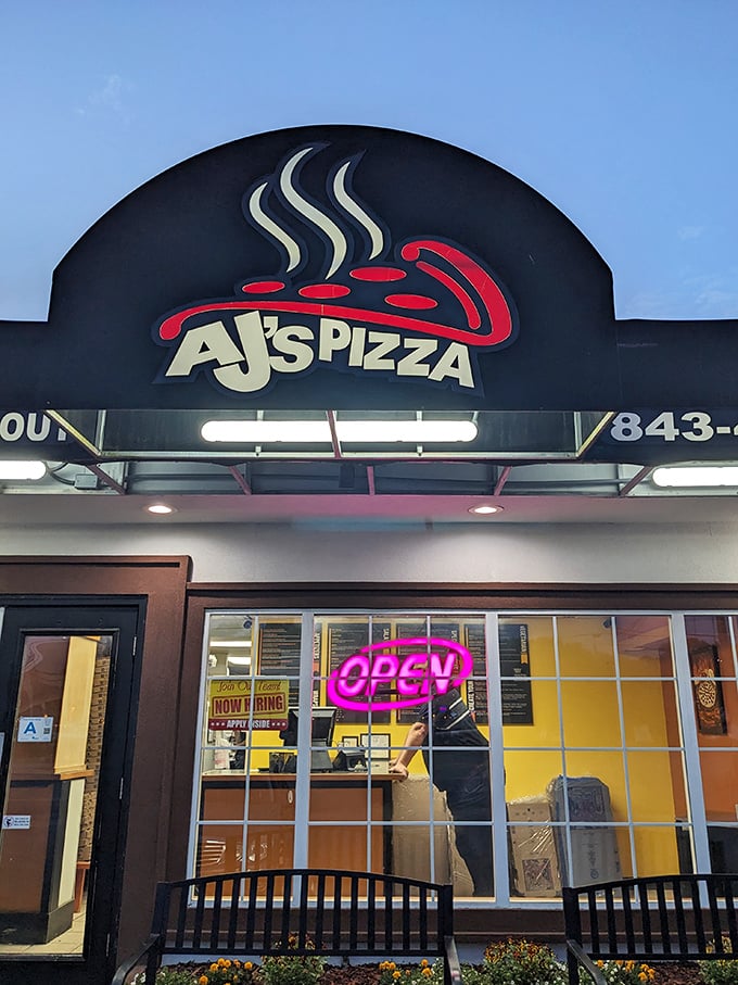 AJ's sleek black awning and steaming pizza logo signal that serious pizza business happens here.