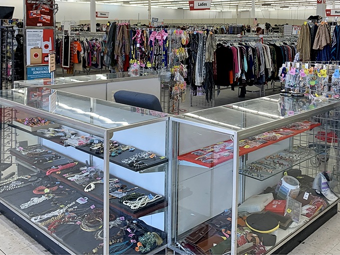 The jewelry counter—a glass-topped museum of costume sparkle where statement necklaces and vintage pins wait to complete outfits not yet imagined.