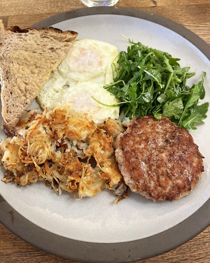 The classic American breakfast, elevated: eggs, potatoes, sausage, and greens arranged with the care usually reserved for much fancier establishments.