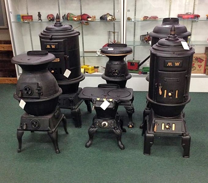 Cast iron stoves stand like Victorian sentinels, their black iron bodies having warmed generations before central heating made everyone soft.
