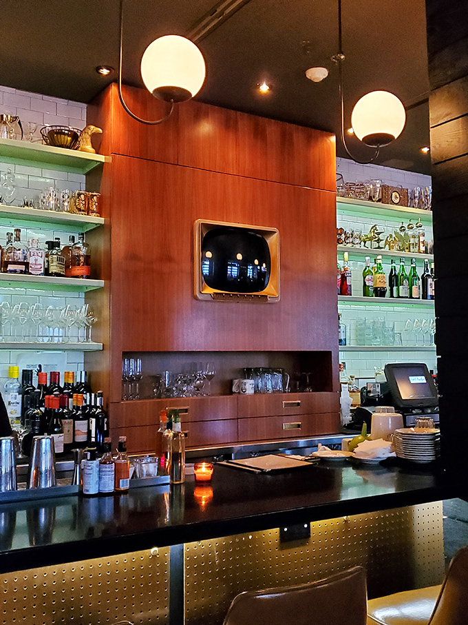 The bar area strikes that perfect balance between retro and modern with its wood paneling, globe lights, and meticulously organized shelves of spirits.