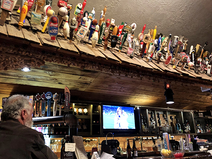 Beer tap handles line the ceiling like stalactites in a cave of adult beverages, each one promising a different path to relaxation.