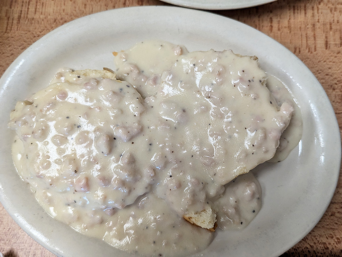 Biscuits and gravy that could settle family feuds. That pepper-speckled blanket of creamy goodness hides treasures beneath.