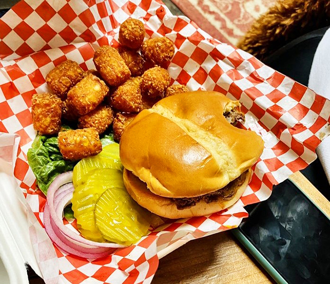 This burger and tots basket doesn't need fancy plating—the red and white checkered paper is all the runway it needs.