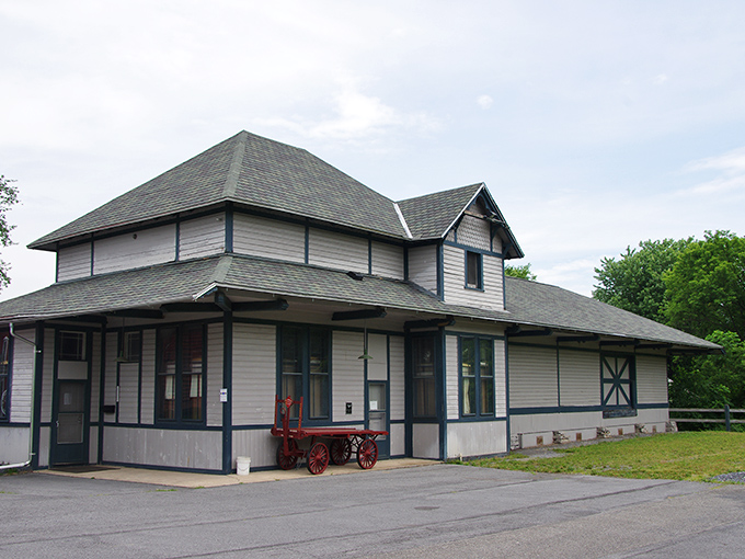 The Clinton Central Model Railroad building preserves transportation history with architectural charm. That baggage cart out front hints at the miniature wonders waiting inside.