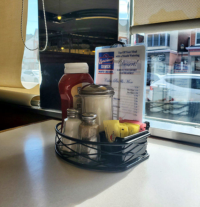 The condiment caddy—a miniature still life of American dining essentials. That sugar dispenser has sweetened thousands of coffee cups and countless conversations.