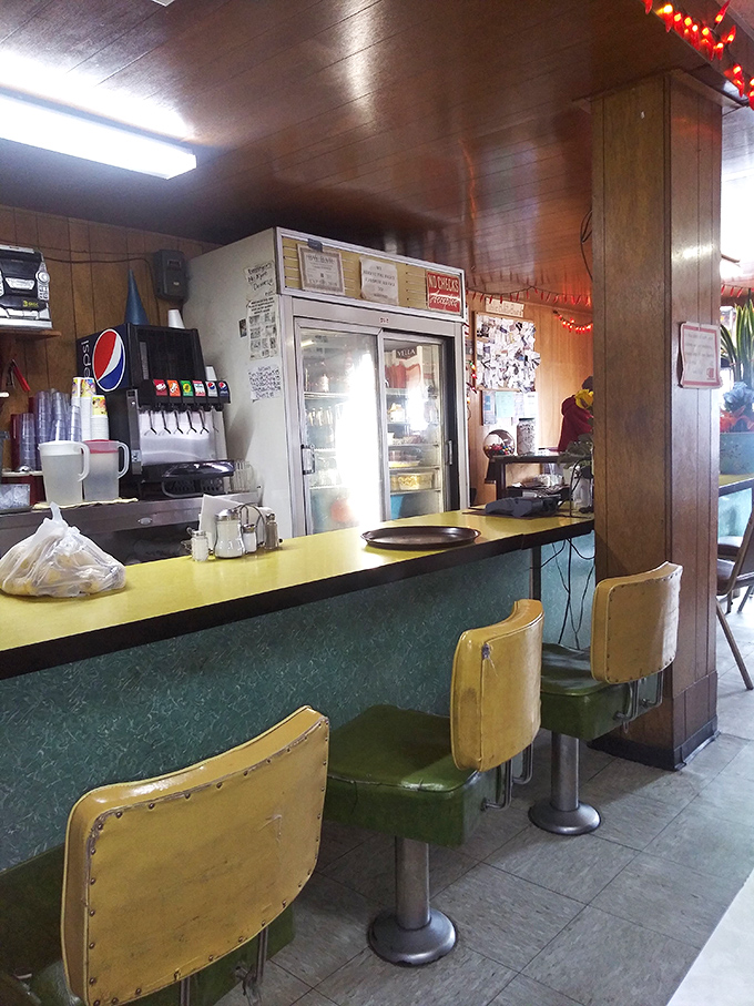 Counter seats where regulars perch like birds on a telephone wire, sharing news and waiting for plates that will momentarily silence all conversation.