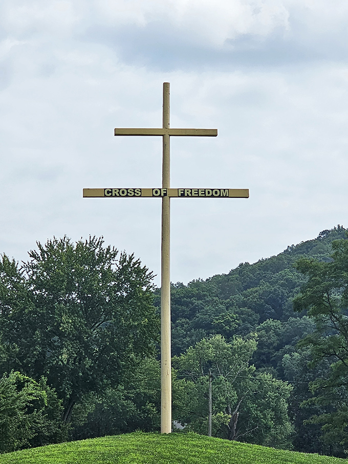 The Cross of Freedom stands sentinel on the hillside, a spiritual lighthouse guiding visitors through this unexpected patriotic sanctuary.