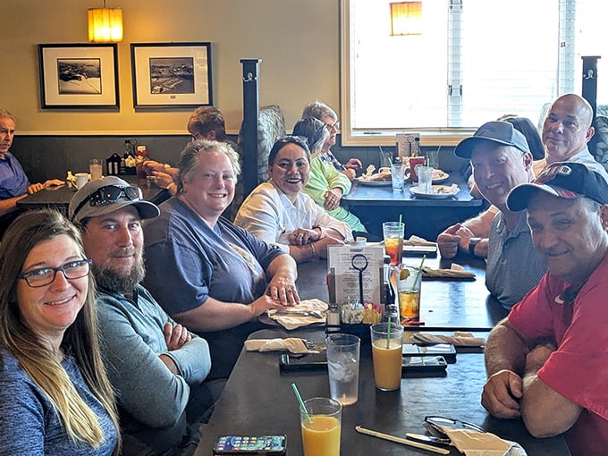 Happy diners sharing stories and laughter around the table&mdash;the universal language of good food bringing people together in this lakeside gem.