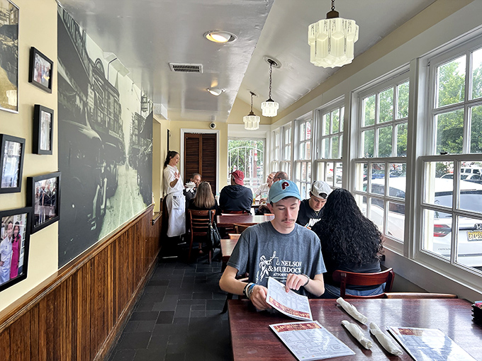 Diners lost in menu contemplation, surrounded by history on the walls and the promise of enormous sandwiches in their future.