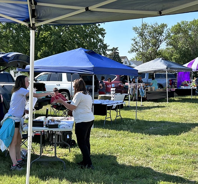 The farmers market transforms an ordinary lawn into a vibrant community hub where handshakes seal deals.