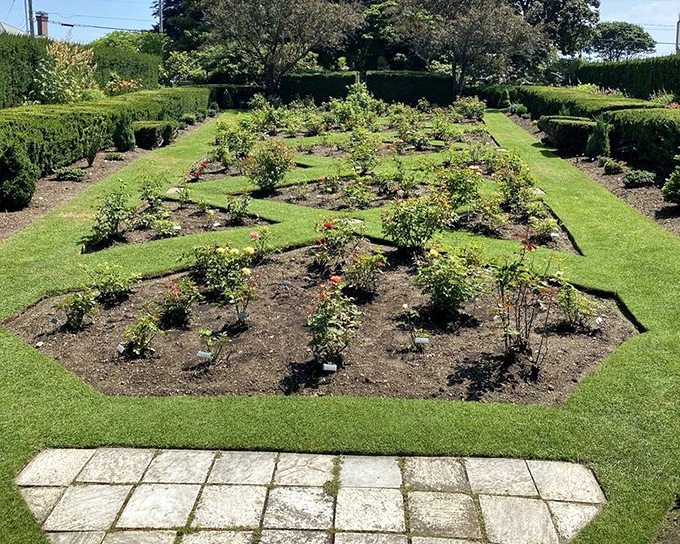 Hedges stand like green sentinels, creating outdoor rooms that would make any interior designer jealous.