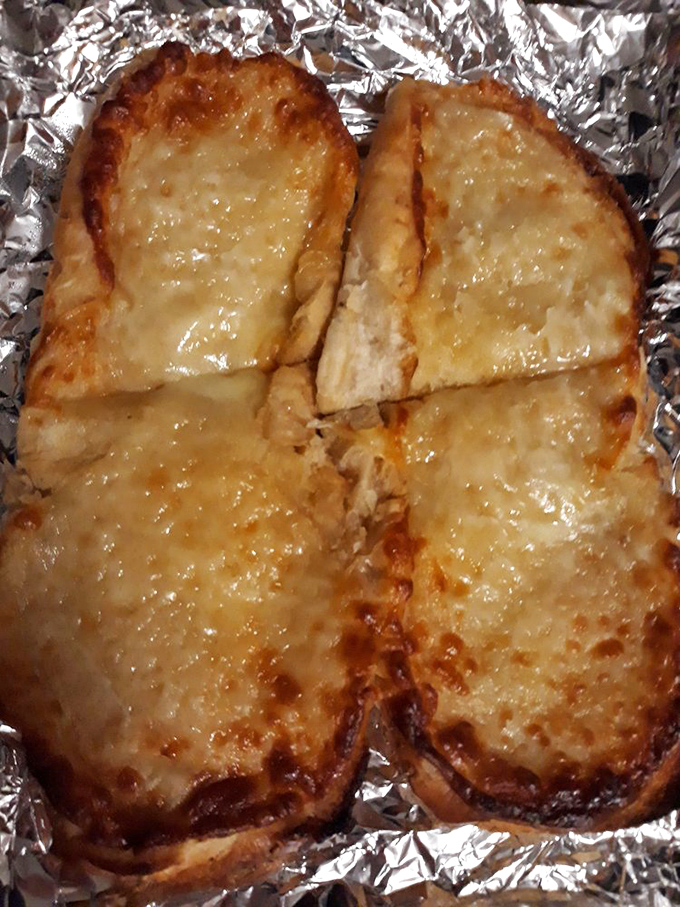 Garlic bread that achieves the golden trifecta: crispy edges, gooey cheese center, and enough garlic to keep vampires at bay for at least a week.