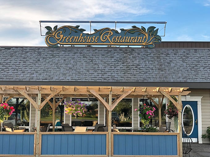 The Greenhouse Restaurant's hanging flower baskets and inviting patio create the perfect backdrop for savoring locally-inspired cuisine under Maine's summer sky.