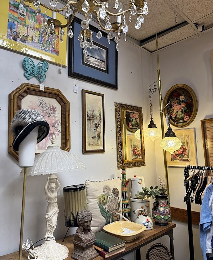 A chandelier illuminates vintage art and a mannequin head, creating the world's most elegant garage sale vignette.