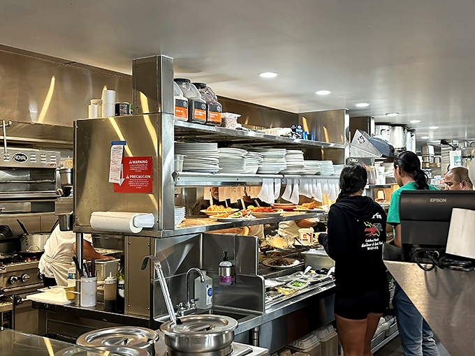 The pass where seafood dreams come true. Stacks of plates waiting for their moment to shine as the stage for oceanic delights.