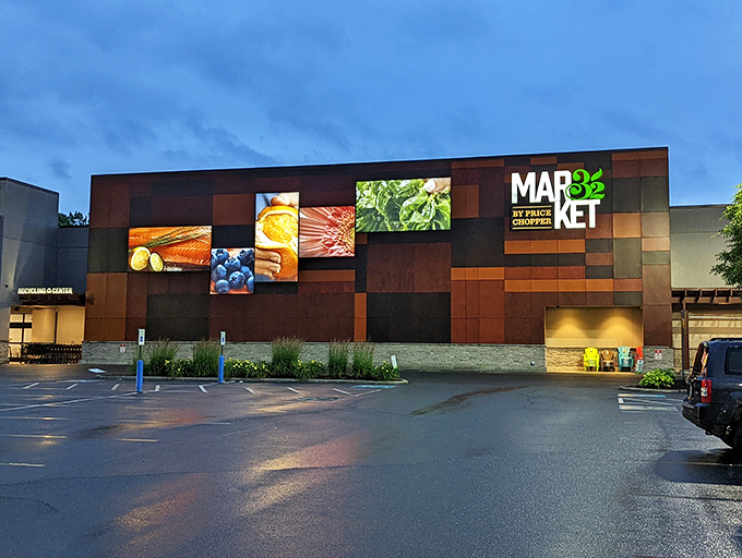 Market 32's modern facade lights up the evening, showcasing fresh local produce through its illuminated display panels.