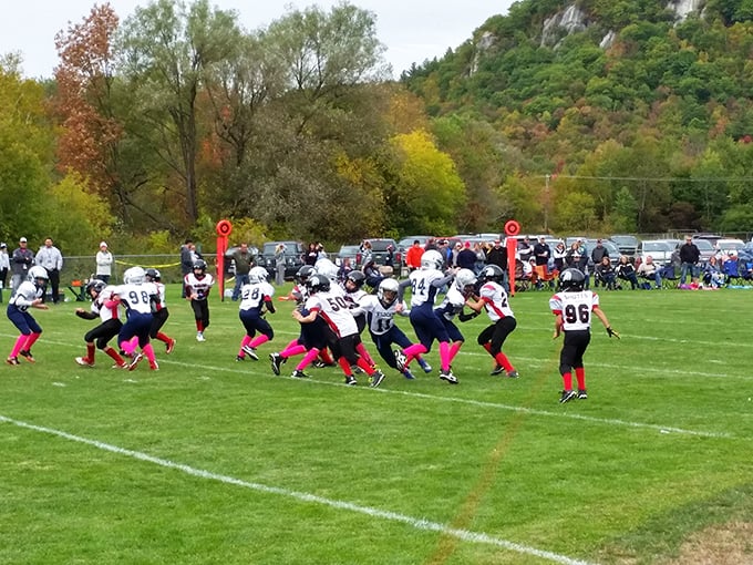 Youth football unfolds against autumn foliage, providing free Friday night entertainment that beats cable television by considerable margins.