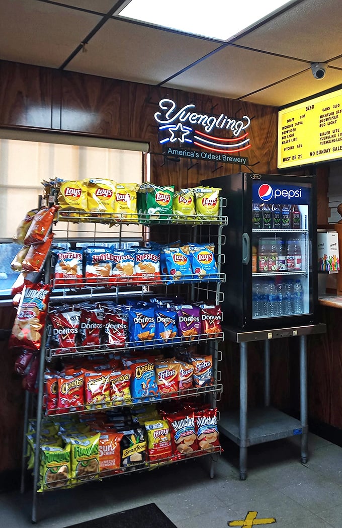 The snack corner offers chips and cold drinks&mdash;because sometimes your pizza needs sidekicks. That Yuengling sign hints at simple pleasures awaiting.