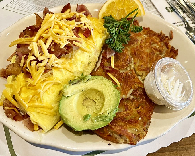 An omelet that's practically architectural, layered with cheese and accompanied by hash browns that achieve the perfect crisp-to-fluffy ratio.