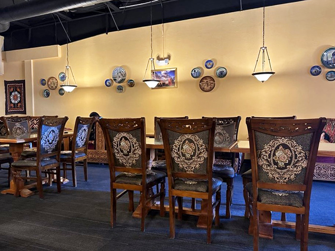 Decorative plates adorn walls above intricately patterned chairs—visual appetizers that prepare your senses for the feast that's about to unfold.