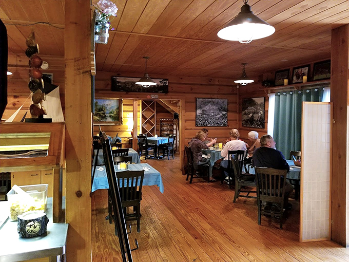Warm wood paneling and blue tablecloths create a cozy mountain lodge atmosphere where conversations and comfort food come together perfectly.