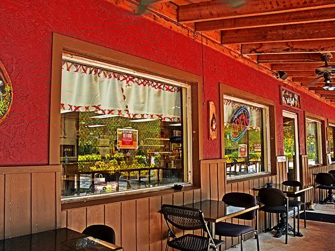 The porch area offers a glimpse into the diner's rustic charm, where red walls and checkered curtains create that quintessential country diner vibe.