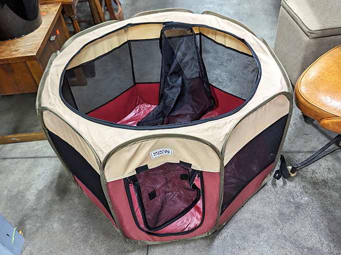A portable pet playpen that's seen better days but still has plenty of puppy containment left in its collapsible frame.
