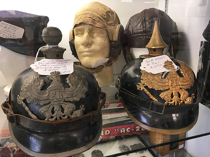 Military helmets that once protected soldiers now stand as silent historians, their brass eagles and insignia telling tales of bygone eras.