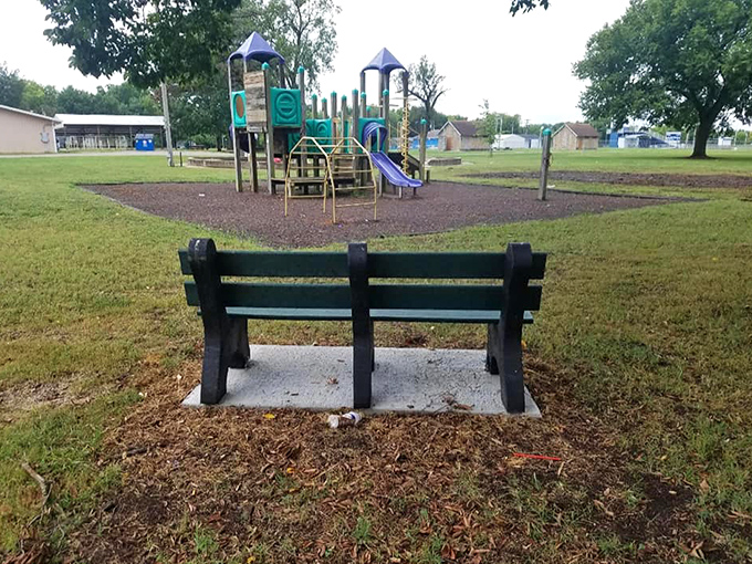 This humble playground bench offers the perfect vantage point for parents watching their children create the same memories they once did.