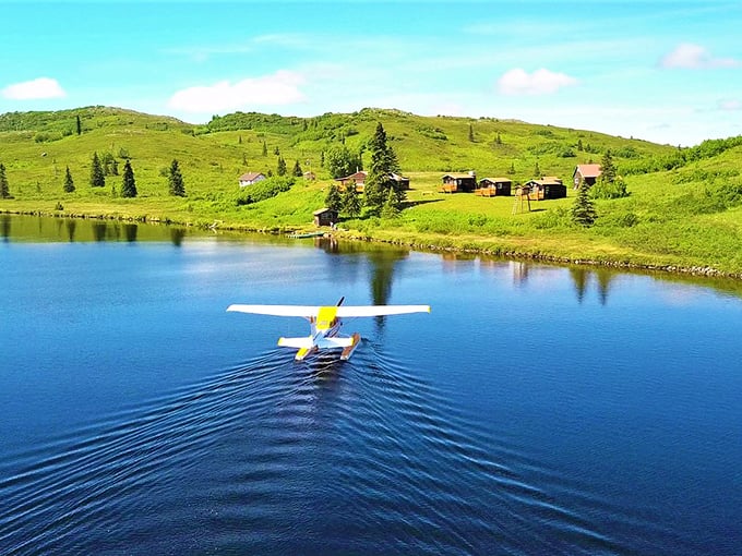 A yellow floatplane creating perfect ripples on a mirror-like lake &ndash; the Alaskan equivalent of a taxi, just infinitely more photogenic.