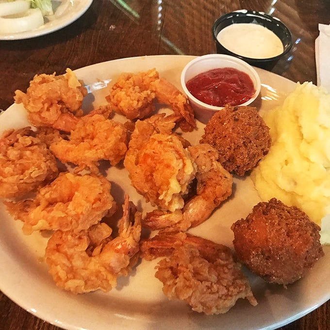 Fried shrimp and hushpuppies share plate real estate with mashed potatoes in this Southern comfort trifecta.