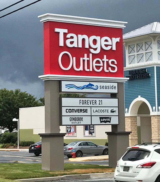 The Tanger Outlets sign stands proud, listing brands like Converse and Lacoste that make your wallet nervous and heart happy.