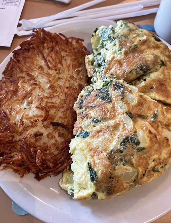 An omelet that proves vegetables can be breakfast heroes too. That hash brown companion deserves its own standing ovation.