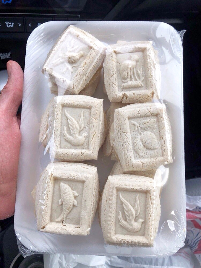 Traditional Springerle cookies dusted with enough powdered sugar to look like they survived their own personal blizzard.