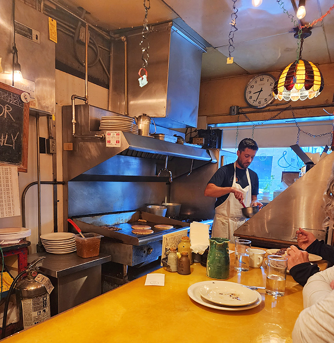 The cook's focused concentration isn't just about making breakfast&mdash;it's about maintaining a culinary tradition in fourteen feet of space.