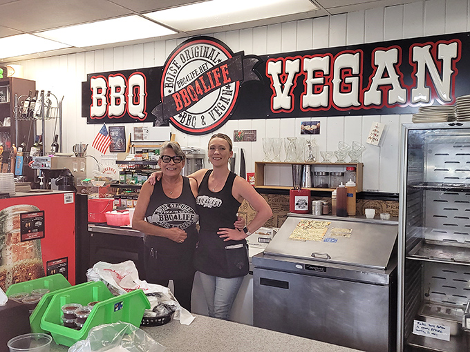 The friendly staff behind that "BBQ & Vegan" sign showing that everyone's welcome at this inclusive barbecue party.