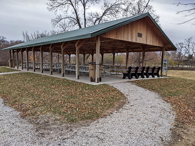 This rustic park shelter offers the perfect gathering spot for community potlucks where casserole recipes are traded like valuable currency.