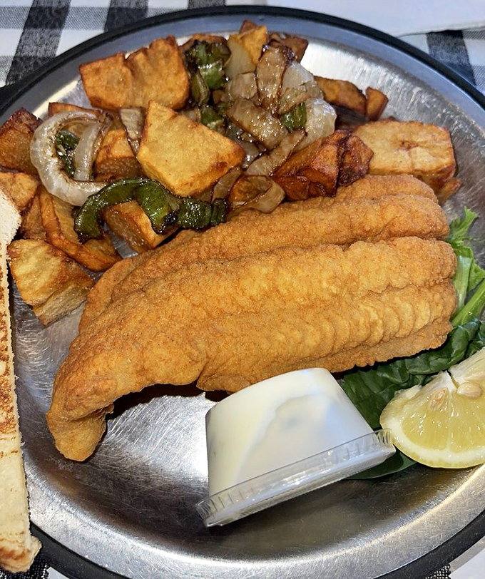 This isn't just fried fish&mdash;it's a golden-crusted revelation served with home fries that have achieved that perfect balance of crispy exterior and fluffy interior.